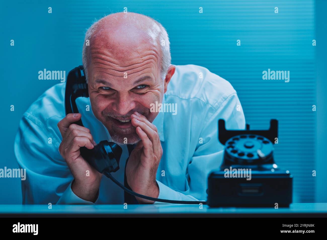 Sly mature businessman with blue eyes and a mischievous smile is ...