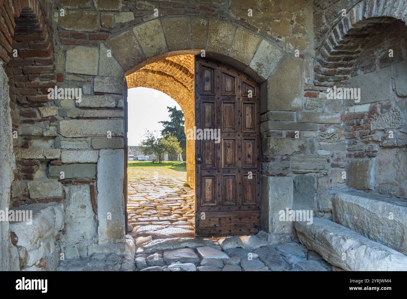Old medieval limestone wall texture building with cobble stone walk way ...