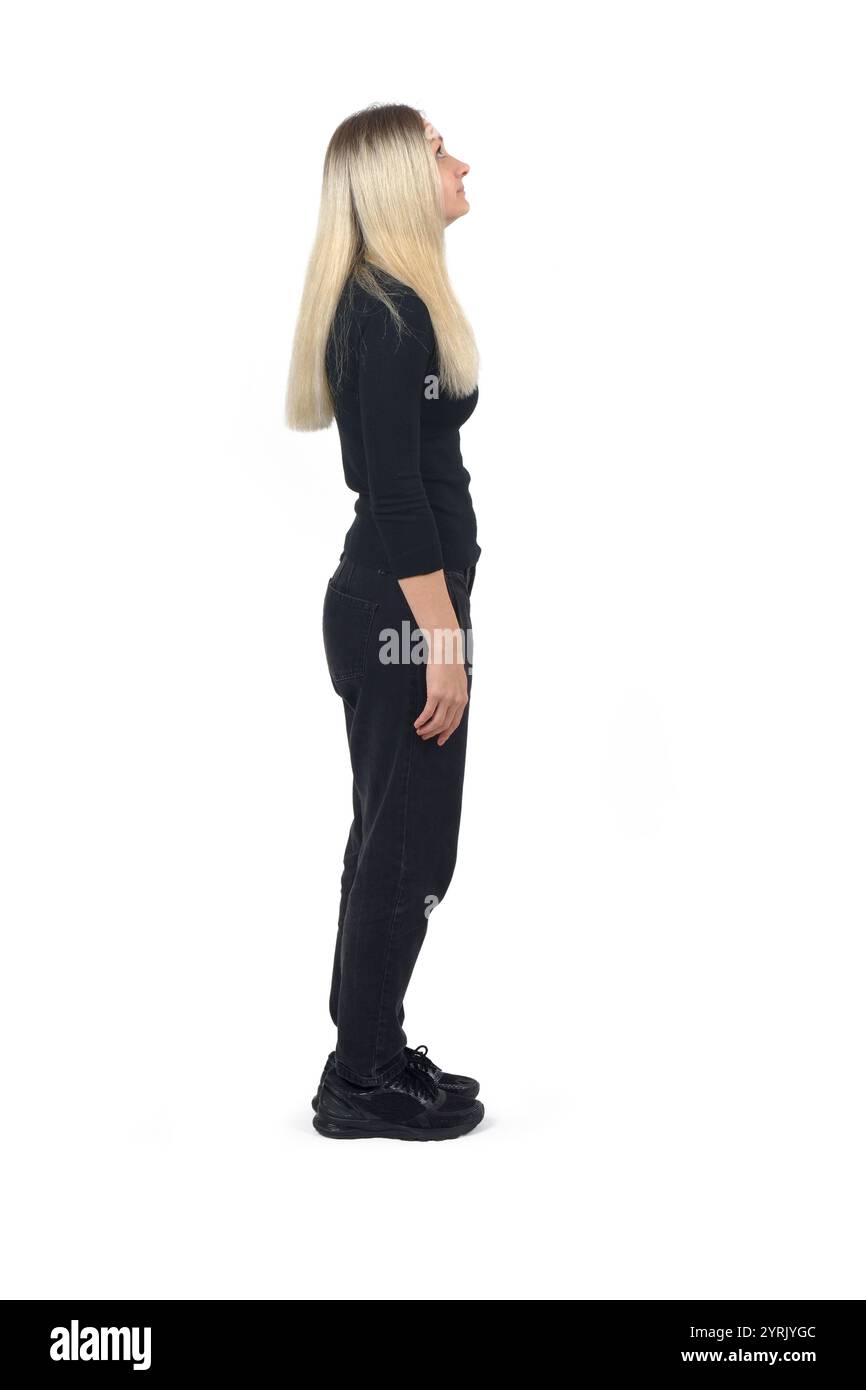 side view of a portrait of a blonde woman standing looking up on white ...
