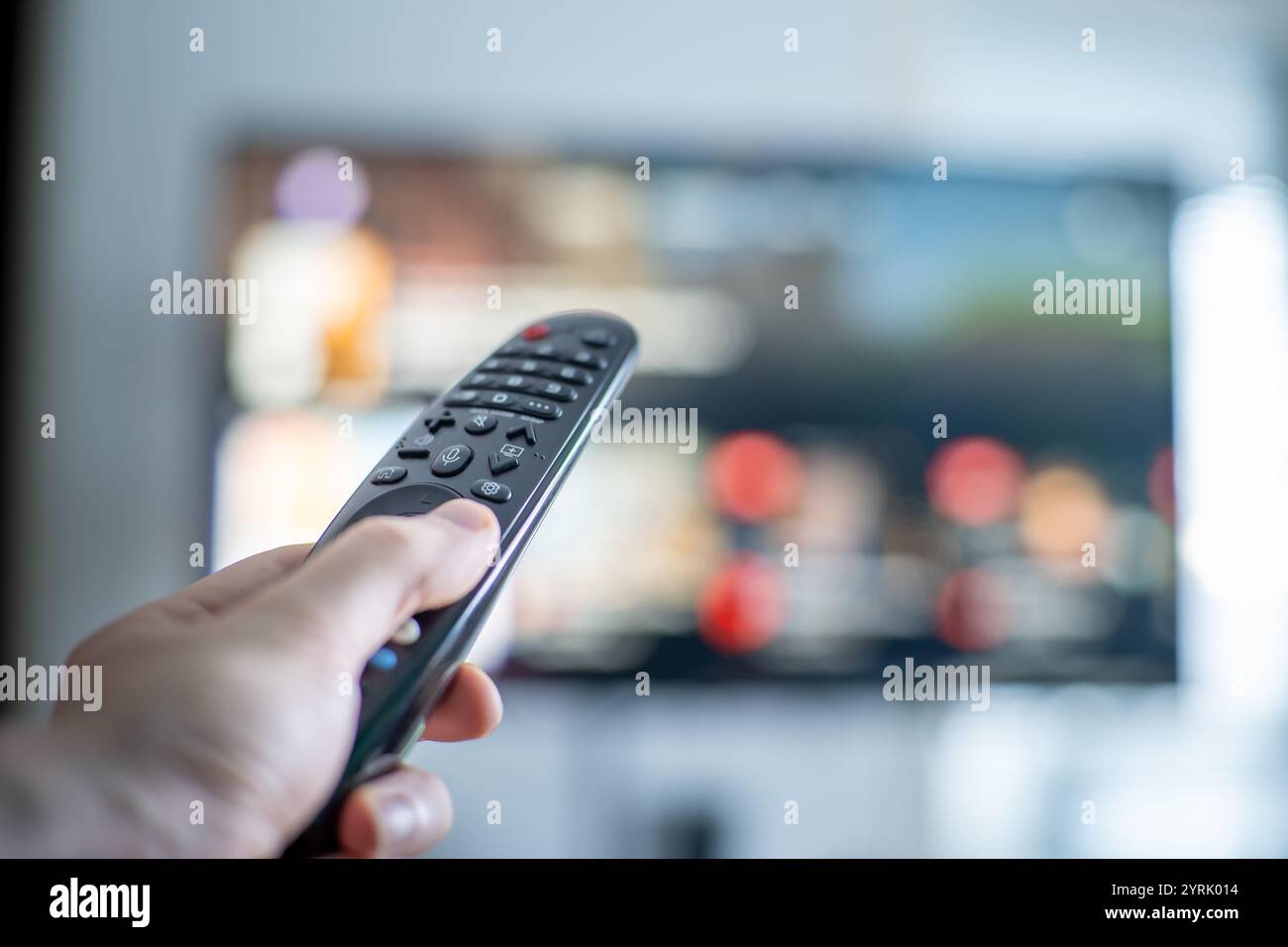 Person's hand changing tv programs by using smart tv remote control ...