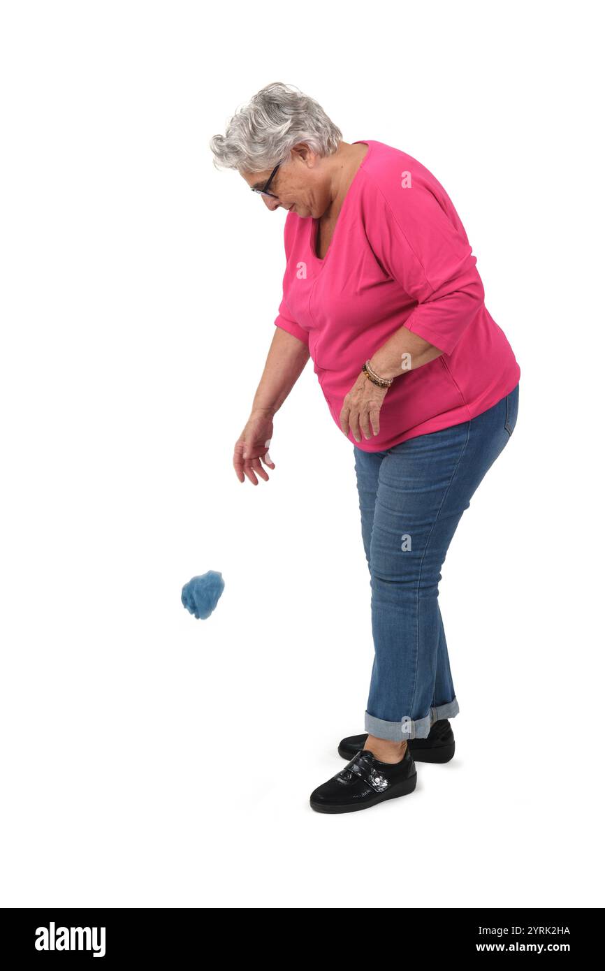 older woman throwing a plastic bag on the ground on white background ...
