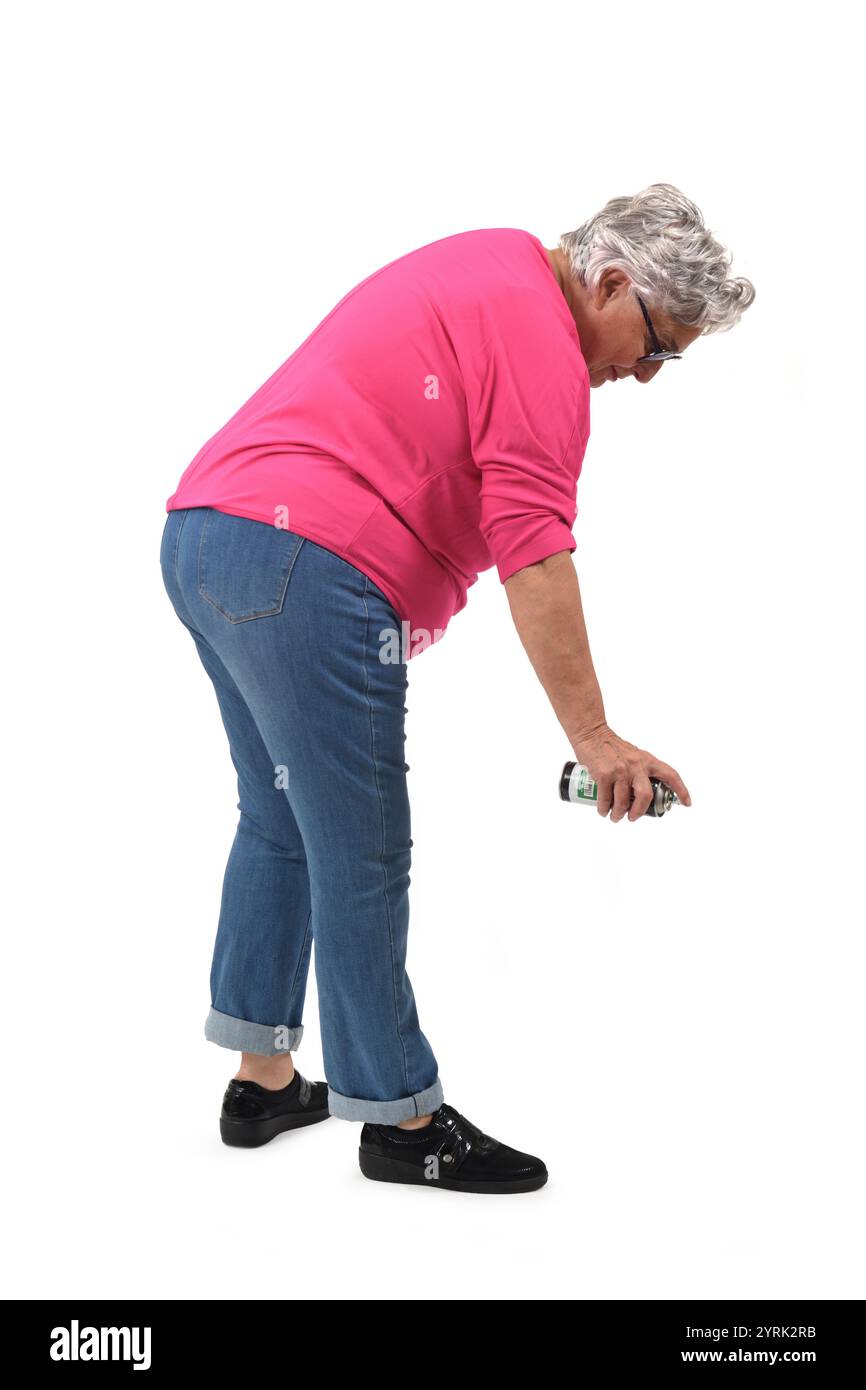 crouched senior woman painting with spray on white background Stock ...