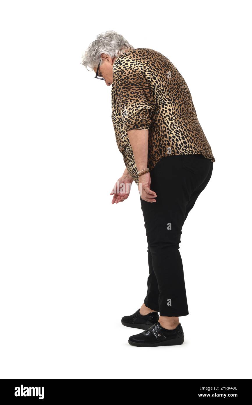 side back view of a crouching senior woman searching for something ...