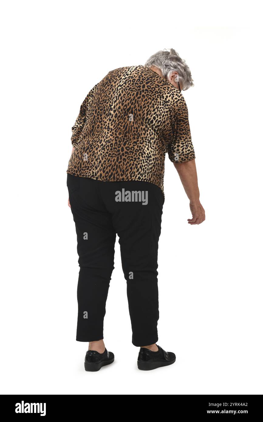 back view of a crouching senior woman searching for something imaginary ...