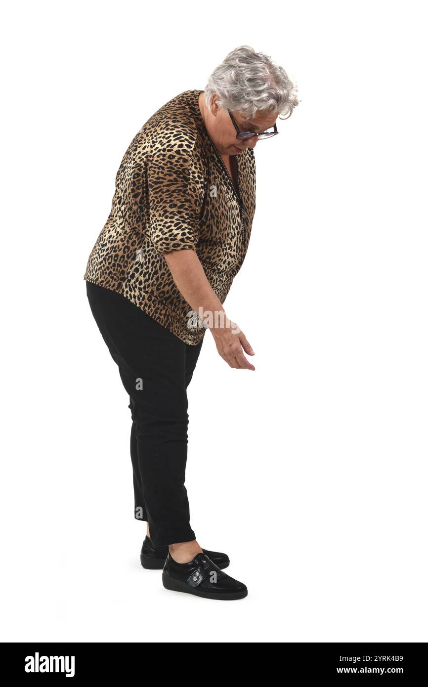 side view of a crouching senior woman searching for something imaginary ...