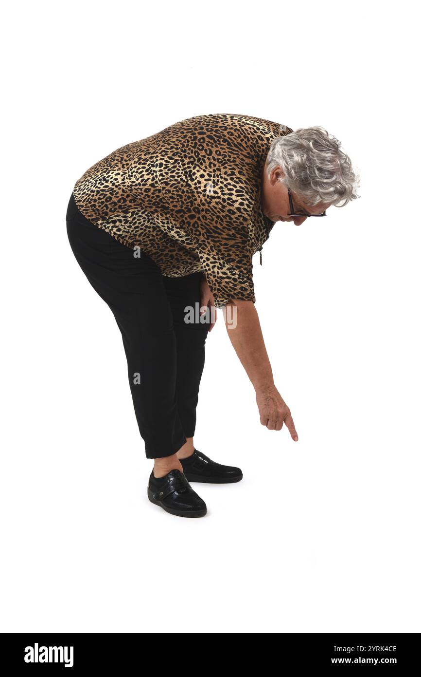 side view of a crouching senior woman pointing with finger on the ...