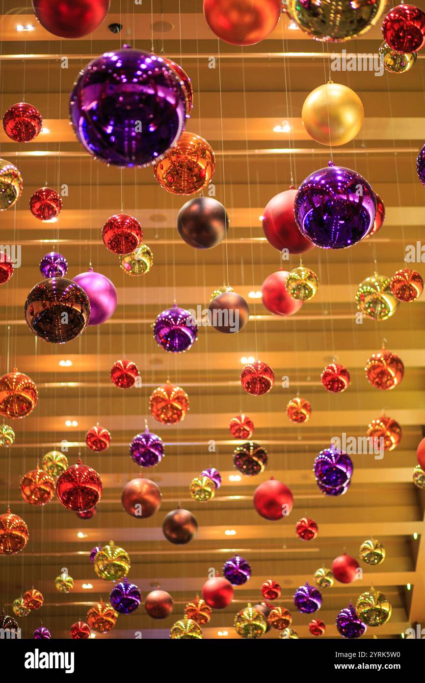 A bunch of colorful Christmas ornaments hanging from the ceiling. The ...