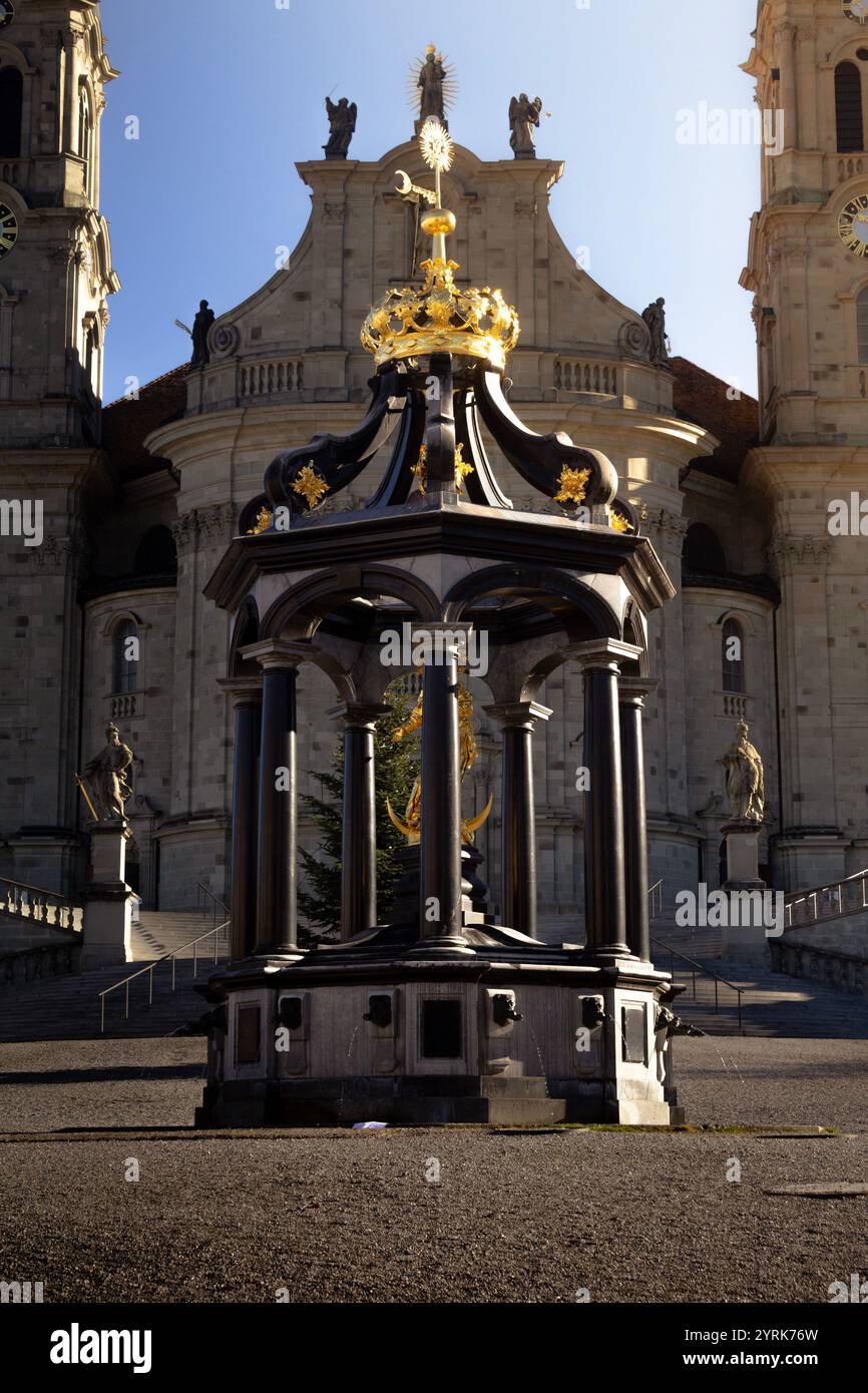 Golden fountain in front of Einsiedeln Abbey, a baroque monastery in ...