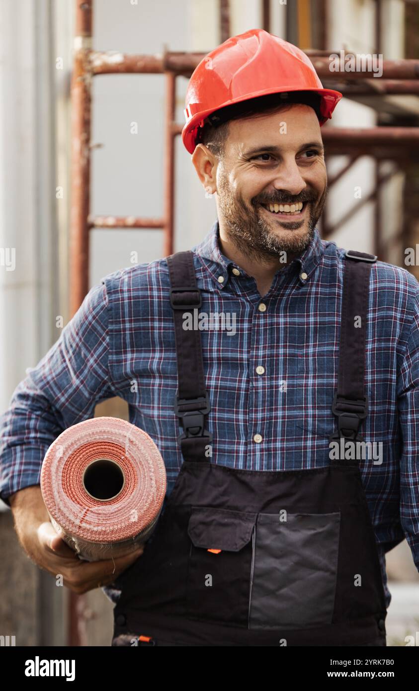Handsome construction worker with helmet carrying reinforcement mesh ...
