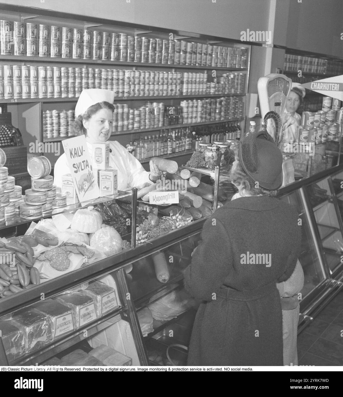In the shop in 1946. A female assistant in a grocery shop, servicing ...