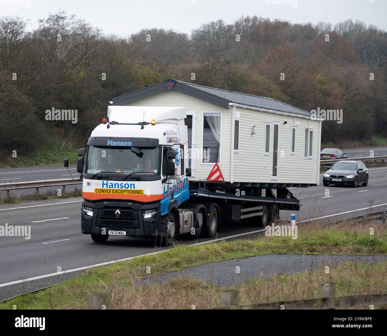 Hanson lorry carrying a small building on the M40 motorway ...