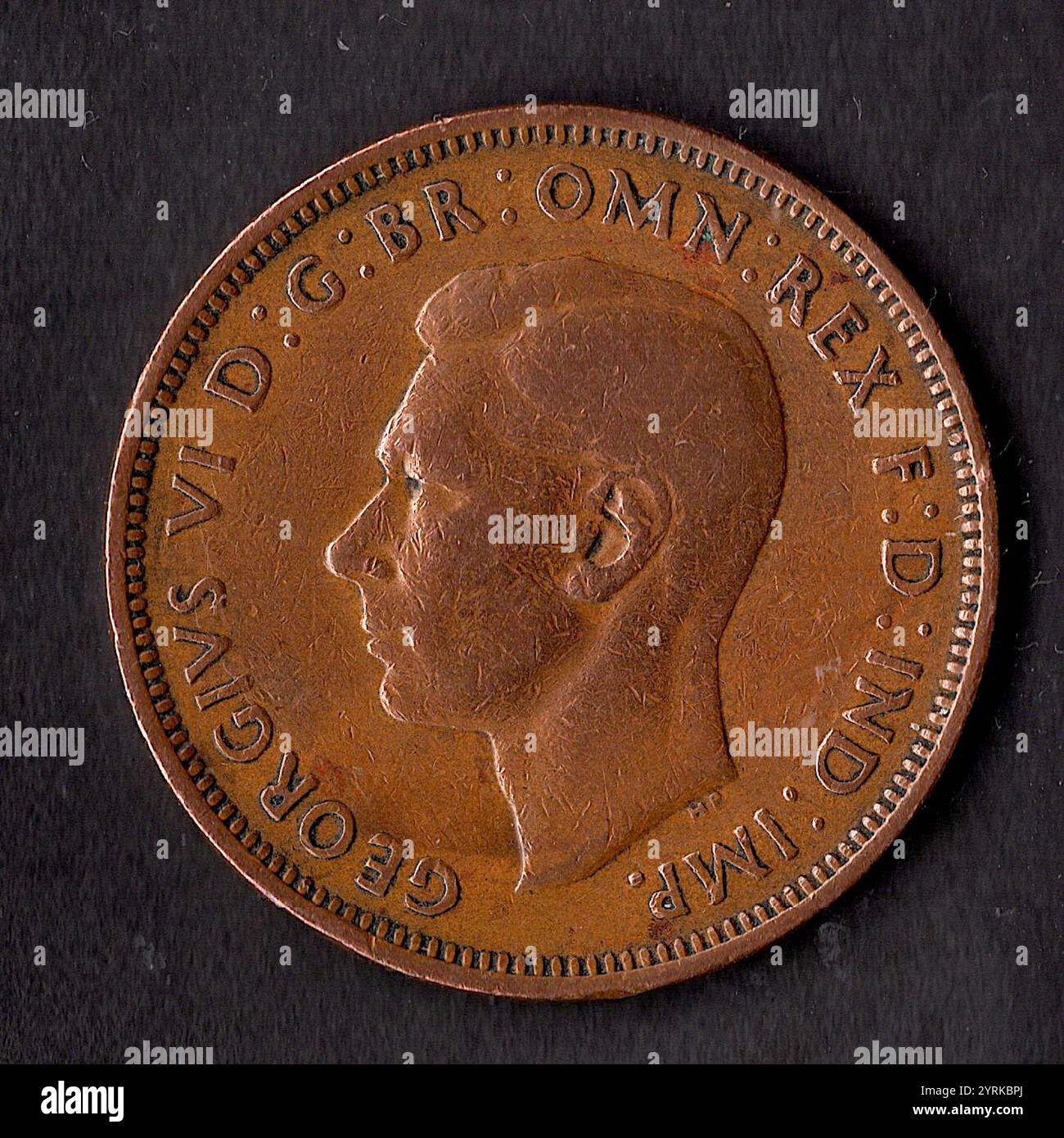 The front of a King George VI half penny from Great Britain on a black ...
