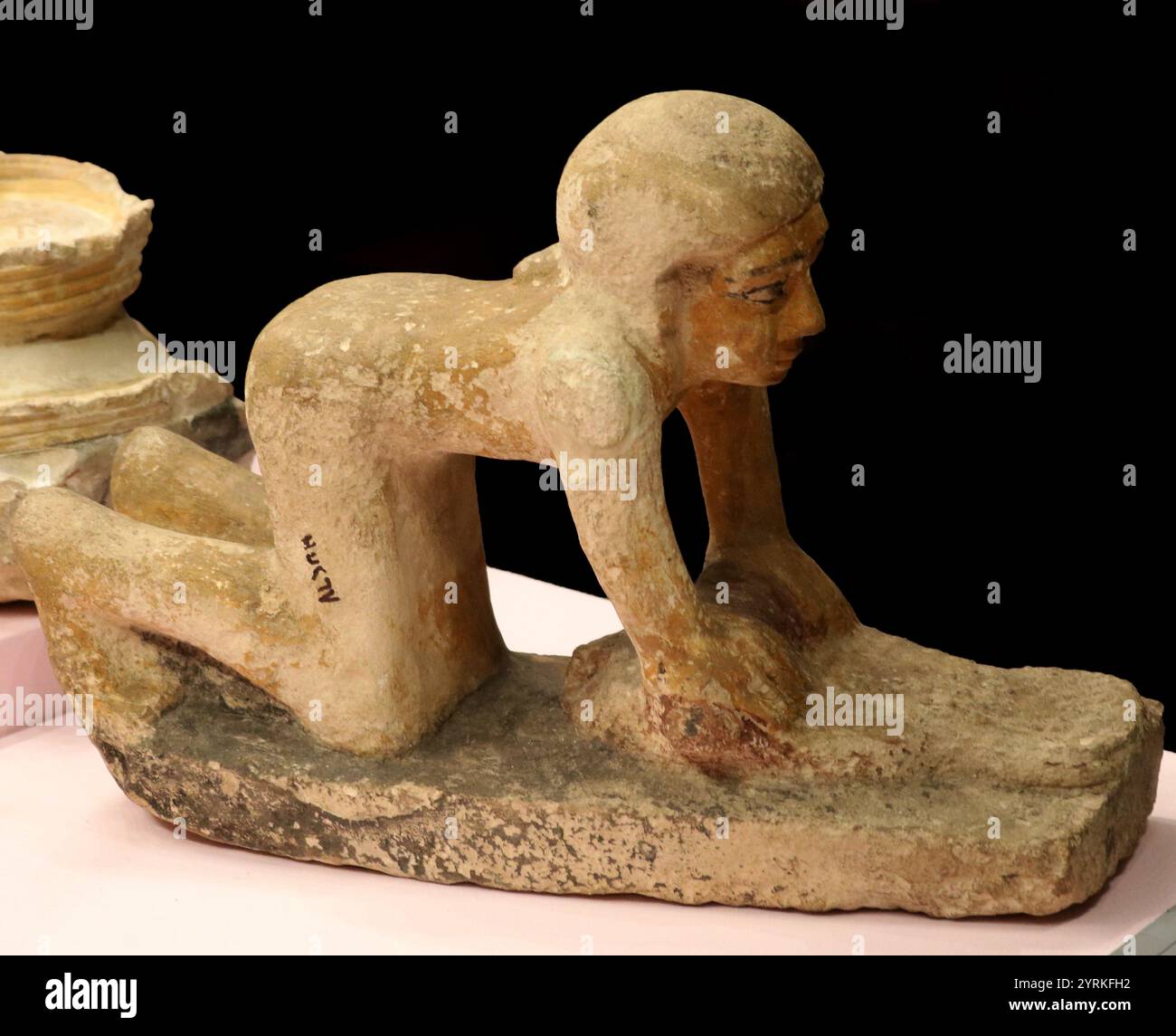 Ancient Egyptian model of a peasant grinding corn to make bread. From a ...