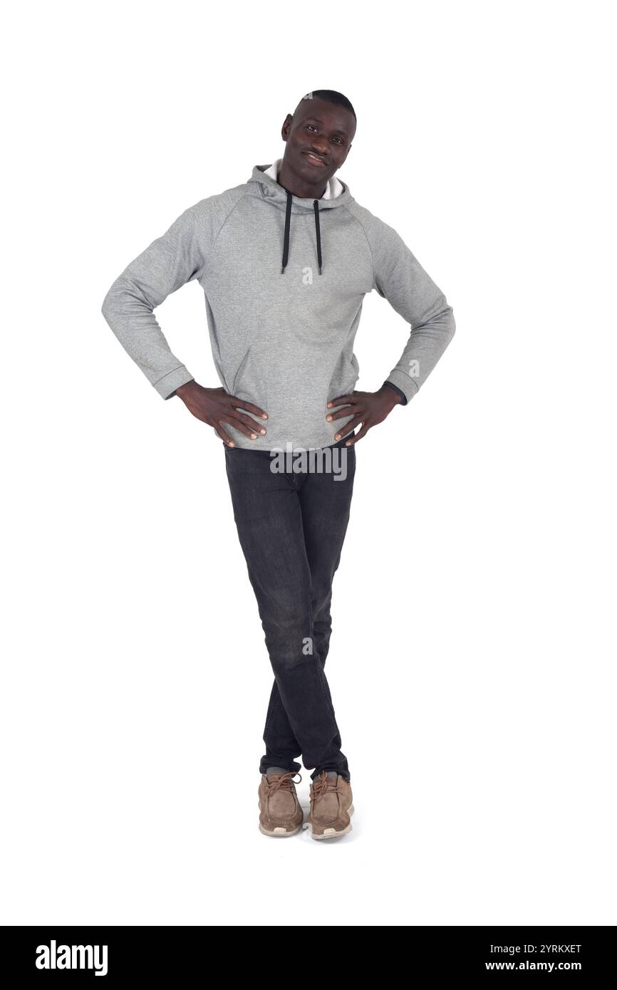 front view of a man standing with arms akimbo and legs crossed on white ...