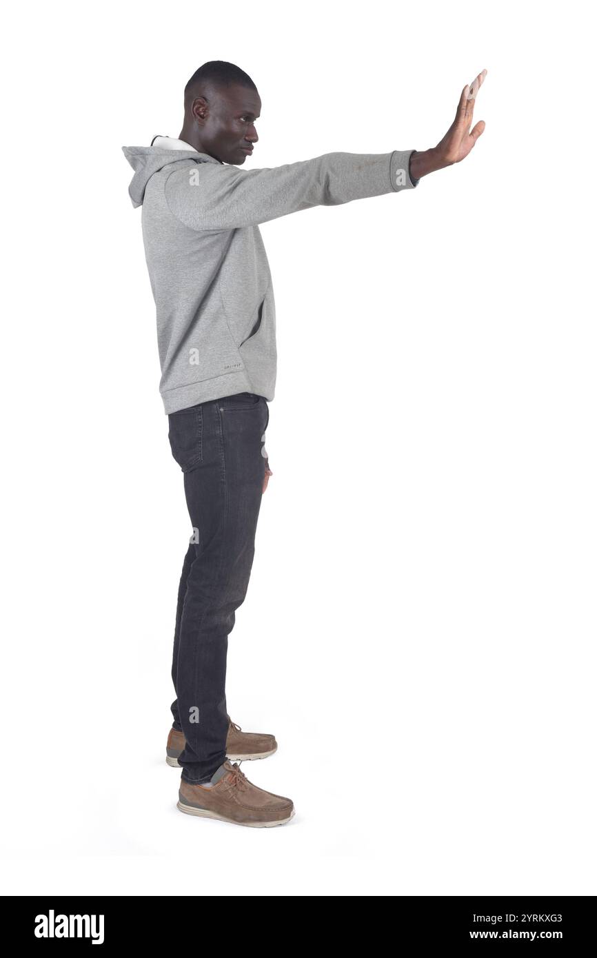side view of a man showing stop sign with his hand on white background ...