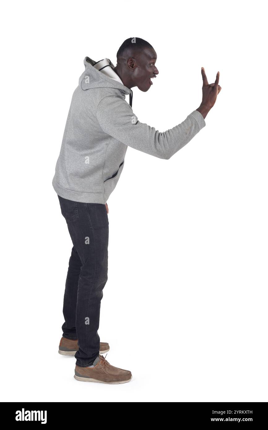 side view of a man showing the horns sign with fingers on white ...
