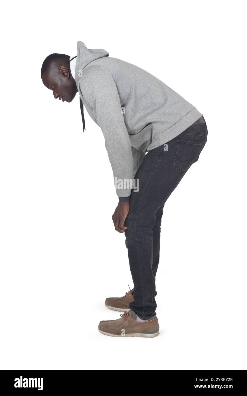 side view of a man crouched down and looking the floor on white ...