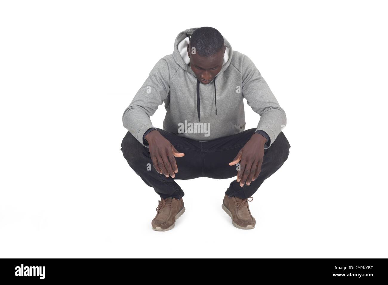 front view of man squatting and looking down on white background Stock ...