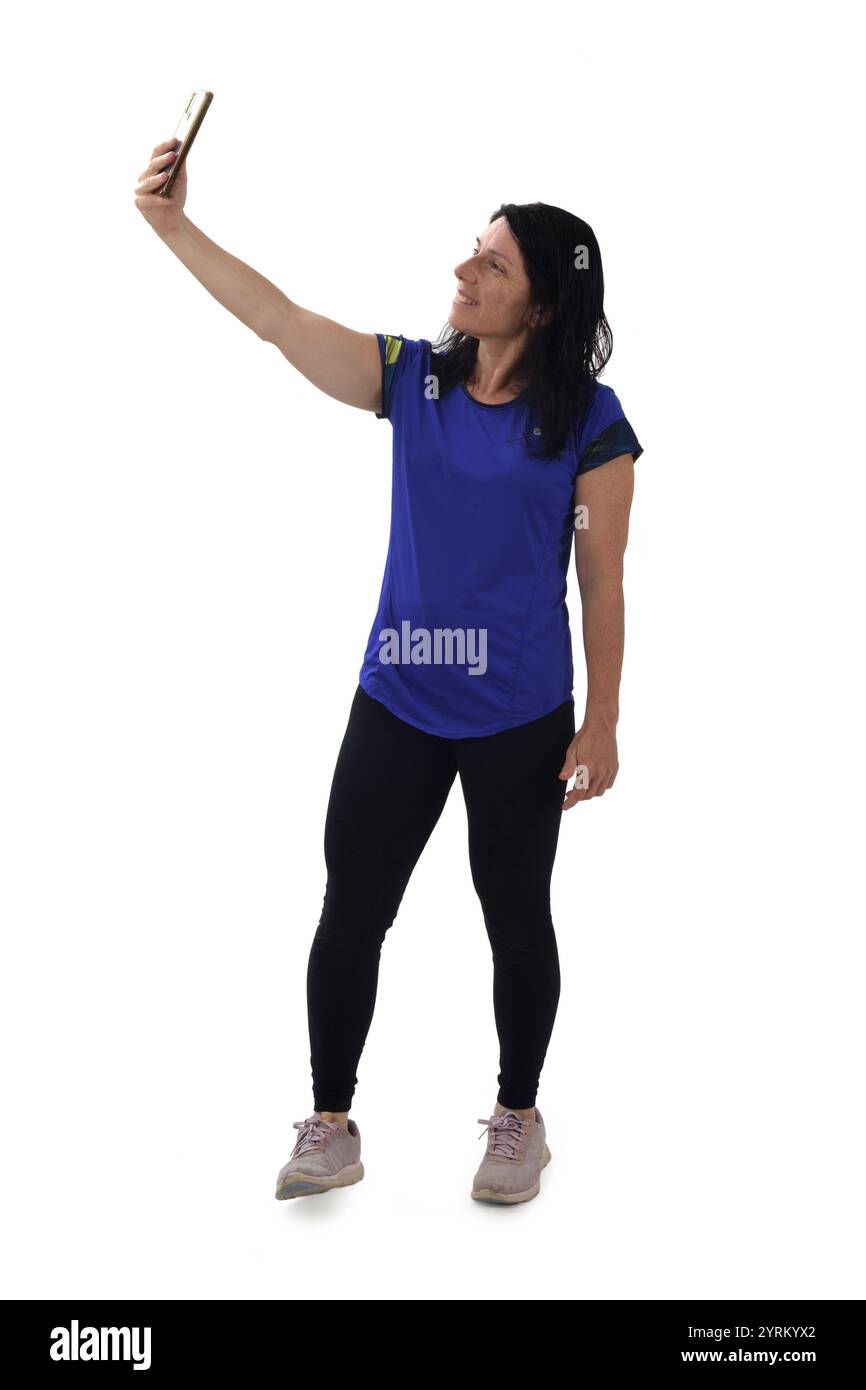 side view of a woman in sportswear with her arm raised making a self ...