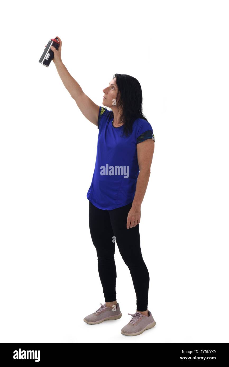 side view of a woman spray painting with raised arm on white background ...