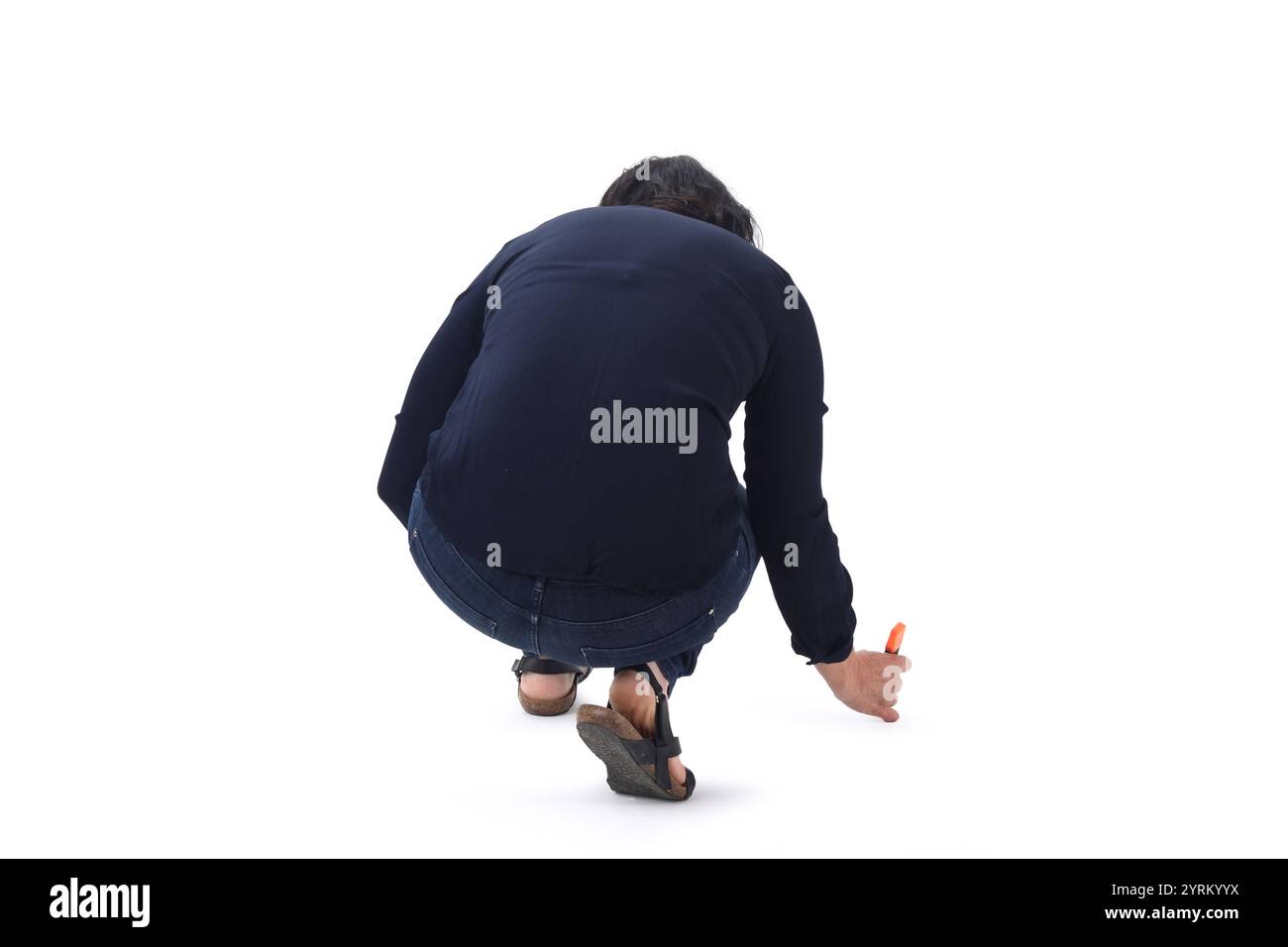 back view of a woman drawing or writing on the floor with a marker on ...