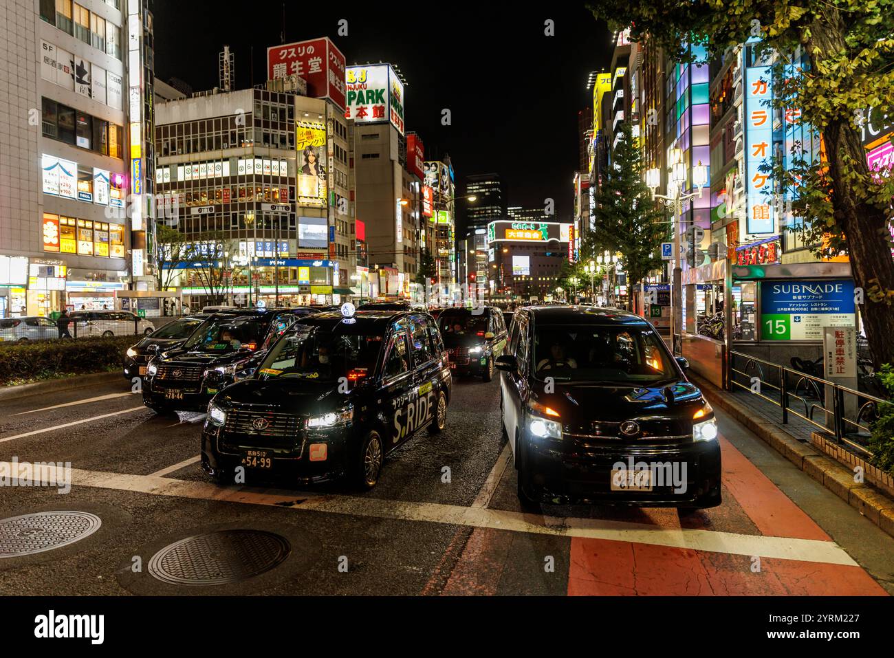TOKYO, JAPAN - October, 22, 2024: A lively and bustling urban nightlife scene, cars on the ...