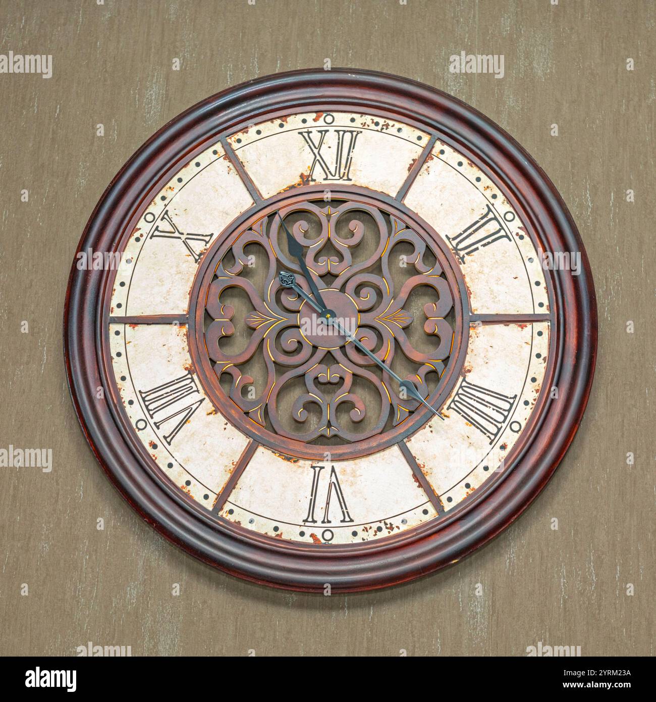 Round Analogue Wooden Clock With Roman Numbers at Grey Wall Stock Photo - Alamy