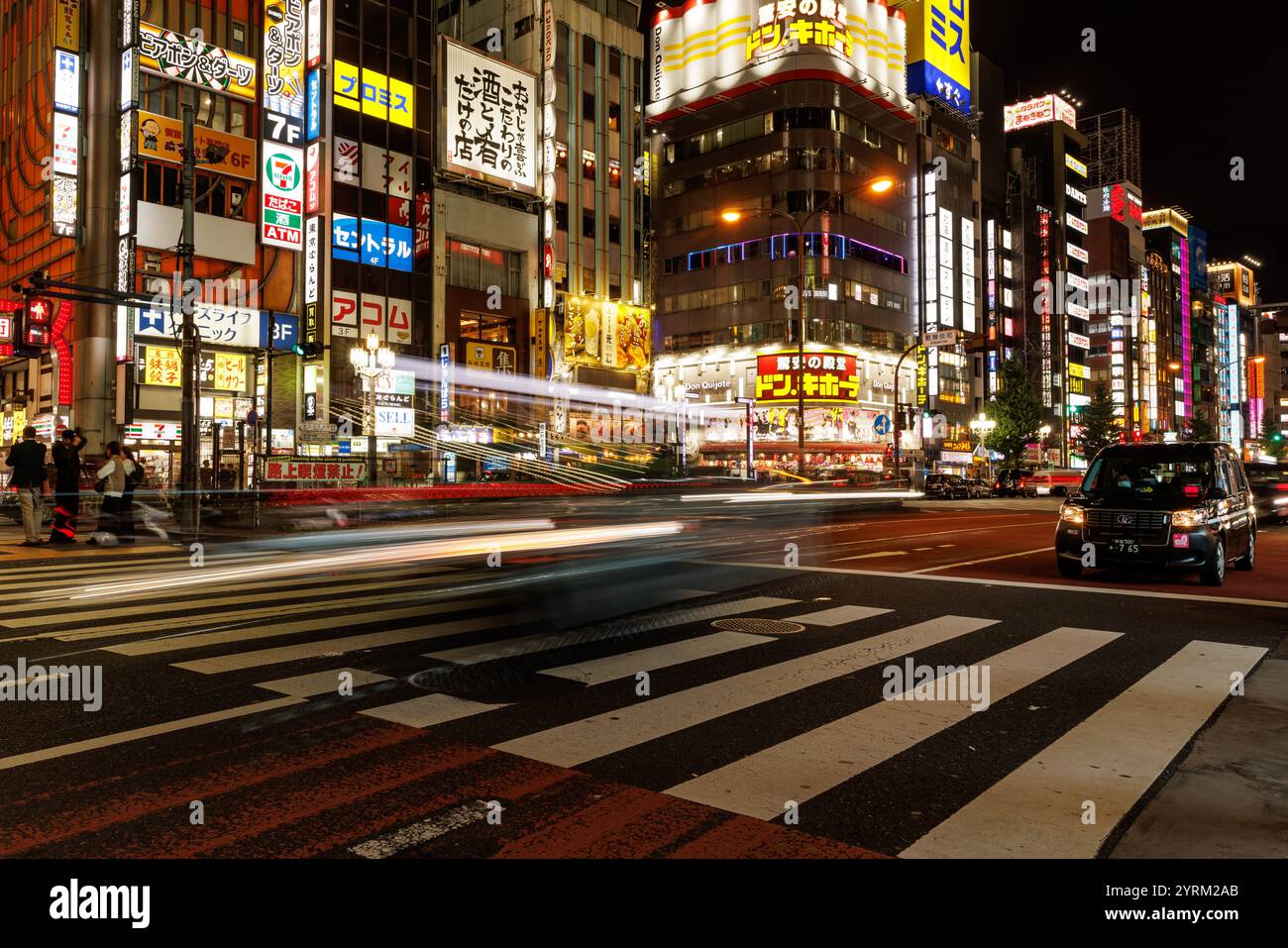 TOKYO, JAPAN - October, 22, 2024: A bustling Tokyo city at night, illuminated by neon signs and ...