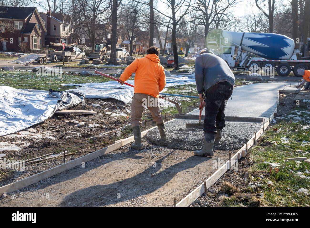 Detroit, Michigan - Workers pour and finish concrete for walking paths ...