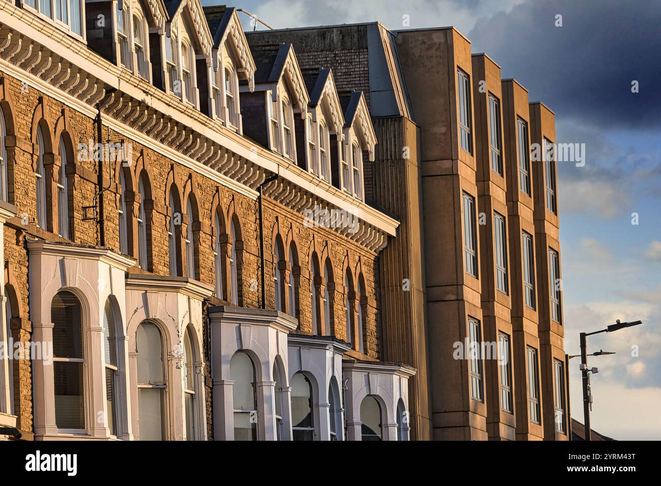 A row of brick townhouses with arched windows and bay windows ...