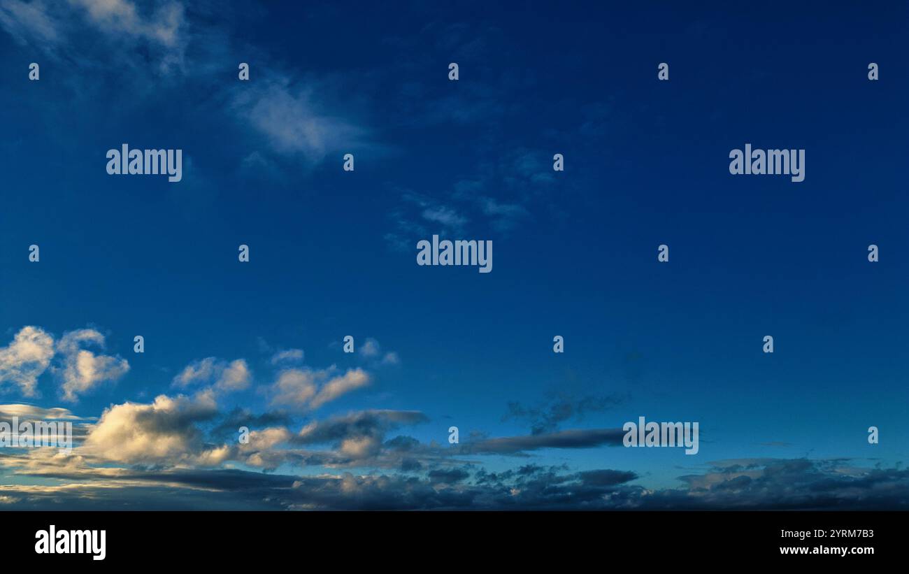 A panoramic view of a mostly clear blue sky with scattered cumulus ...