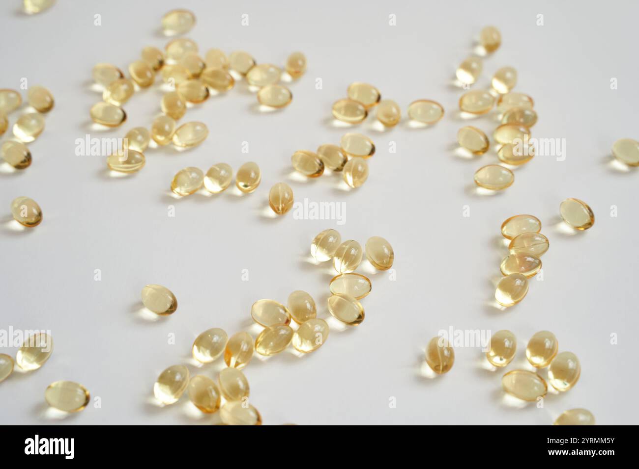 Clear capsules scattered on white background highlighting health and ...