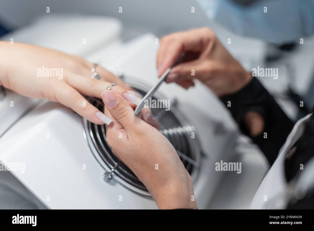 Professional woman manicurist doing manicure and filing nail with nail ...