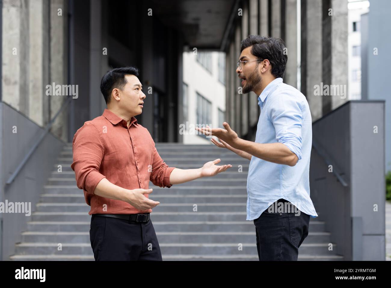 An intense exchange between two colleagues on office stairs captures a ...