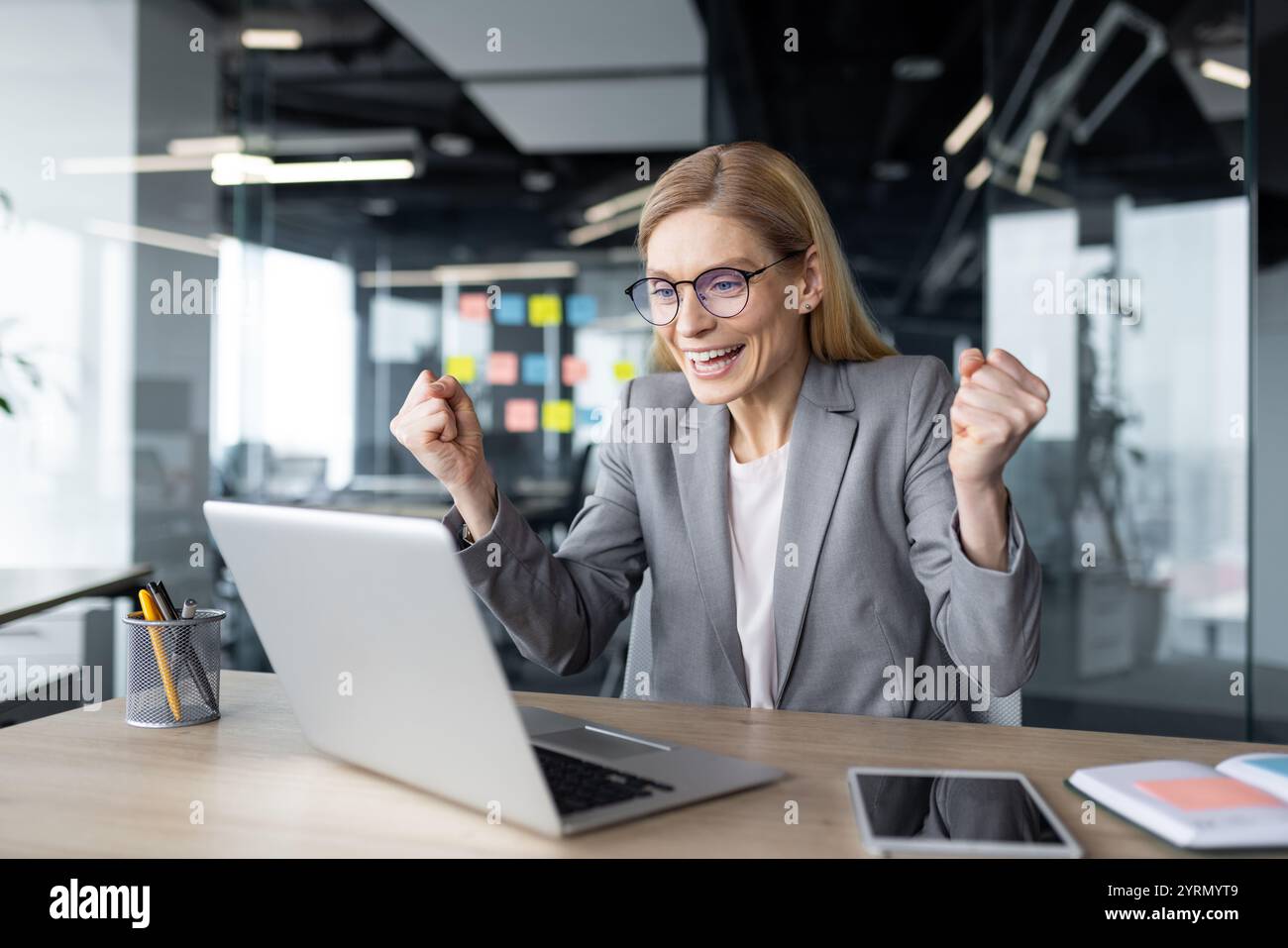 Mature businesswoman expressing excitement as she celebrates a work ...