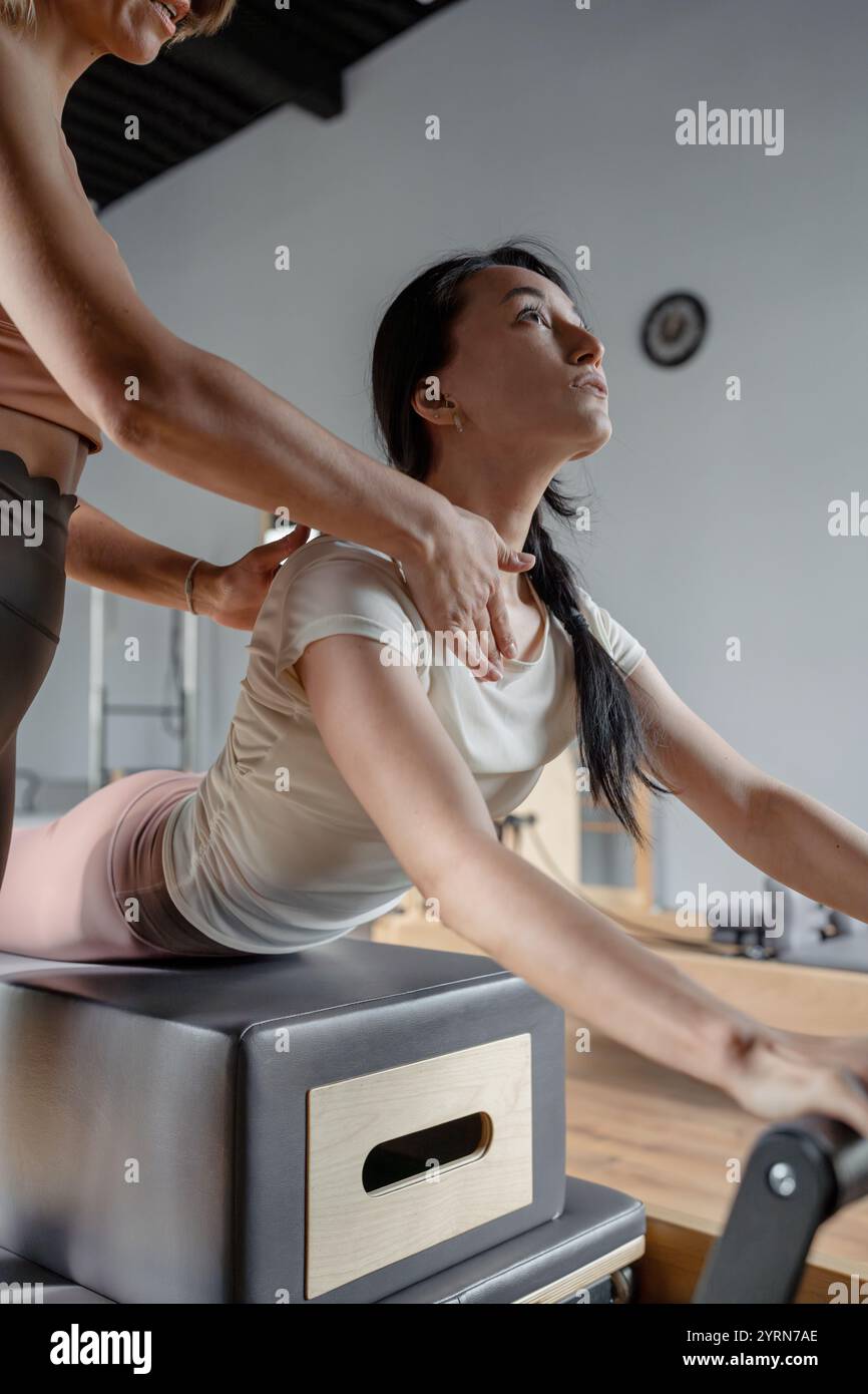 Woman doing Swan exercise on Pilates Reformer for the chest and back ...
