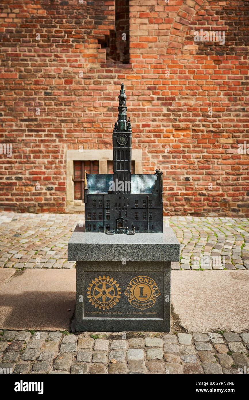 A detailed bronze model of a historic building displayed on a stone ...