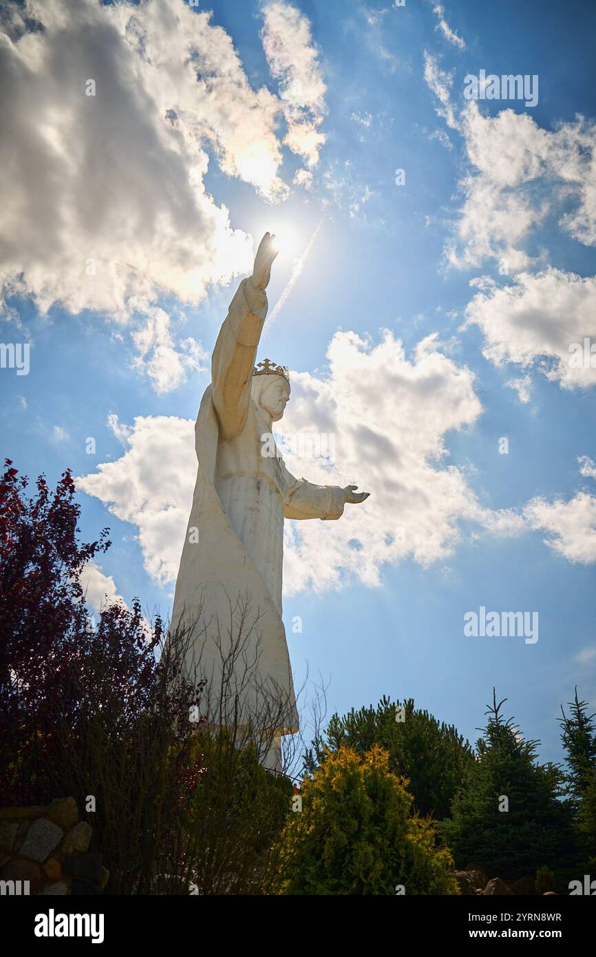A towering statue of Christ with outstretched arms against a backdrop ...