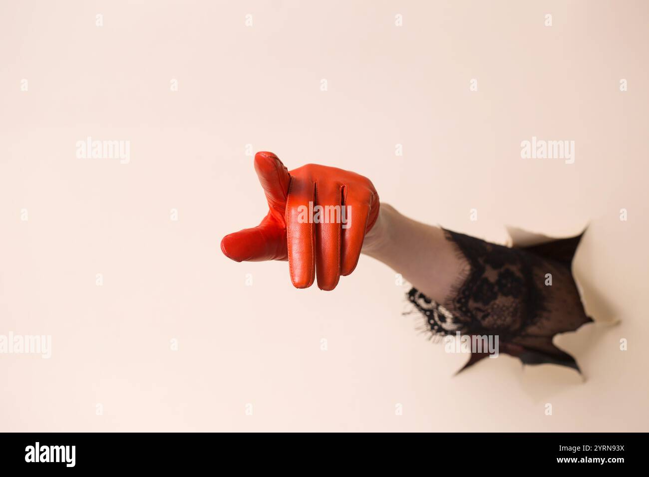 A woman's hand in a leather glove shows a gesture. The hand is pushed ...
