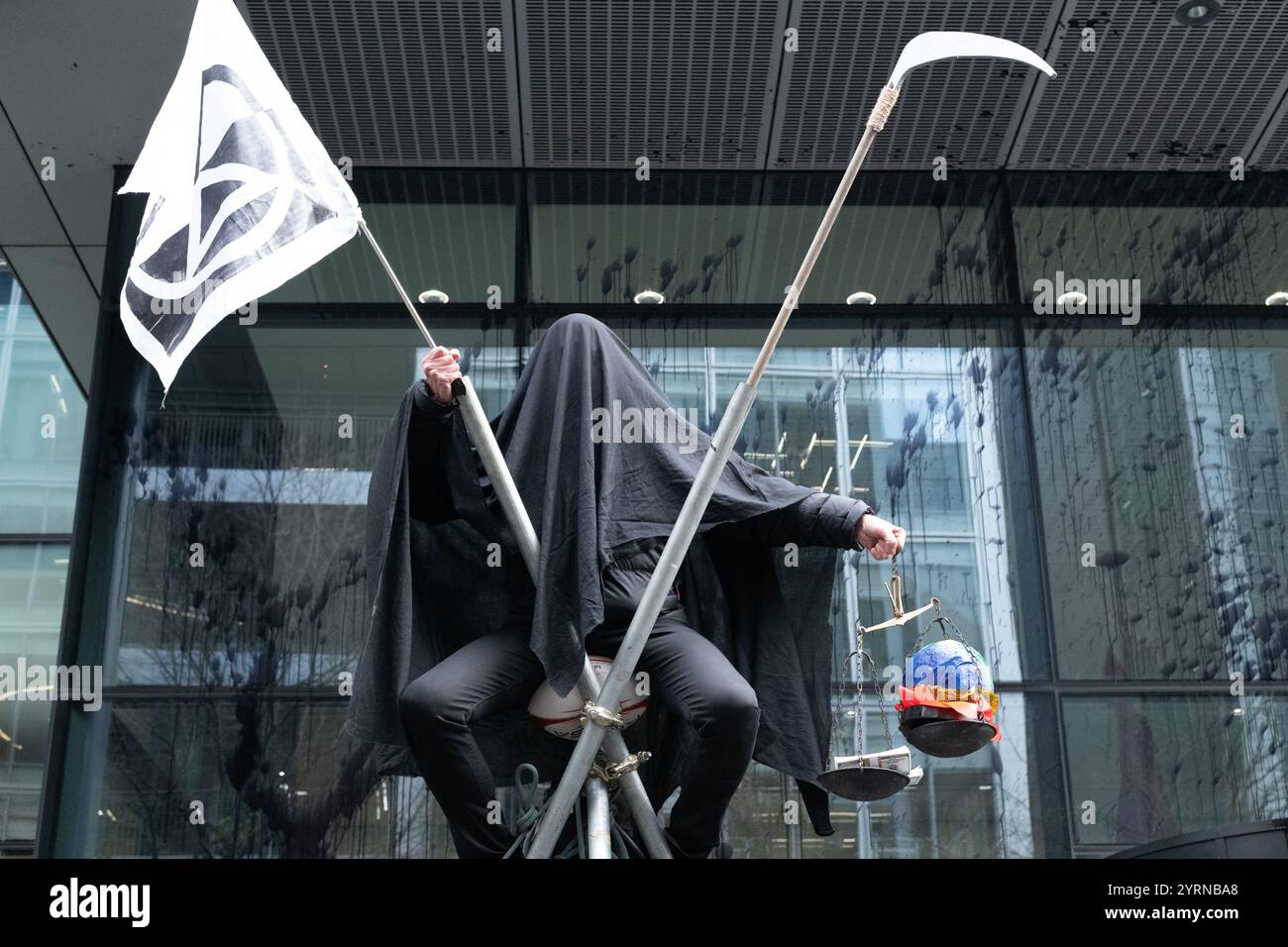 London, UK. 4 December, 2024. An activist dressed as the grim reaper ...