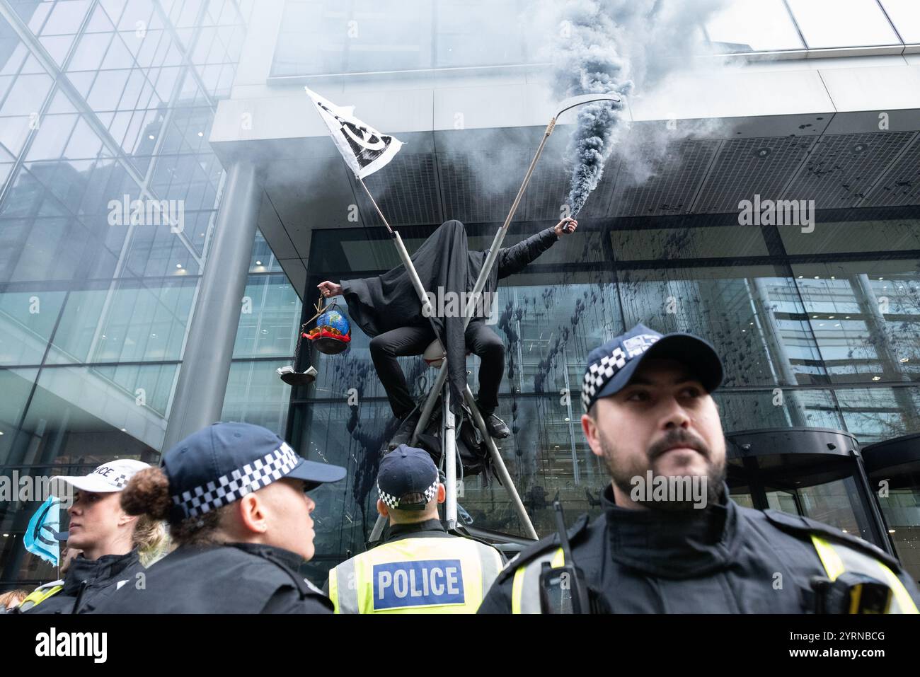 London, UK. 4 December, 2024. A man sitting atop a tripod dressed as ...