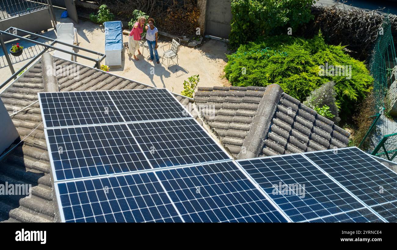 Aerial view of two women celebrating solar panels on a rooftop Stock ...