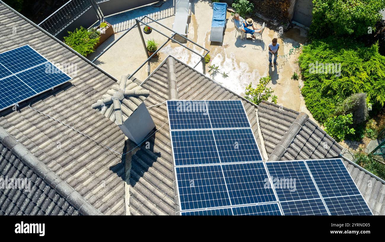 Aerial view of women relaxing and gardening in a backyard with solar ...