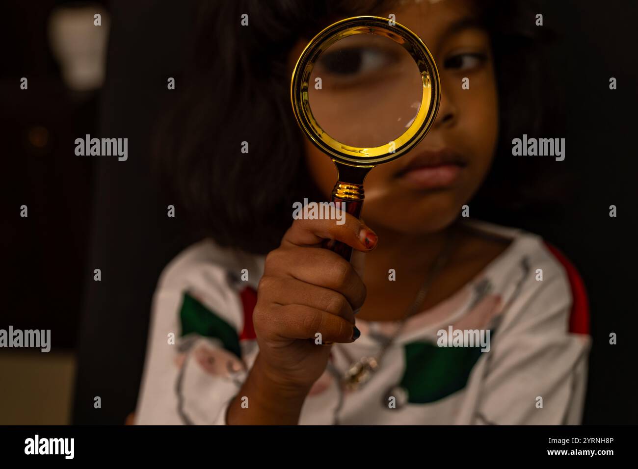 Young girl explores with a magnifying glass, sparking curiosity and ...