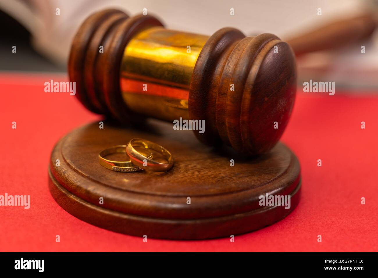 Wedding rings rest beneath a judge's gavel, symbolizing the finality of ...