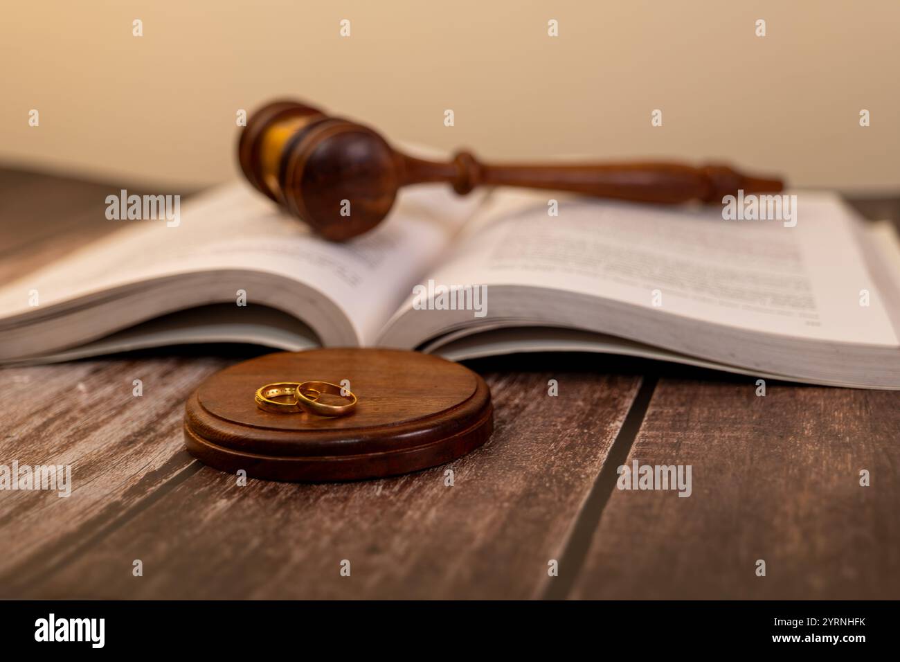 Wedding rings rest on a gavel base with a law book and gavel ...