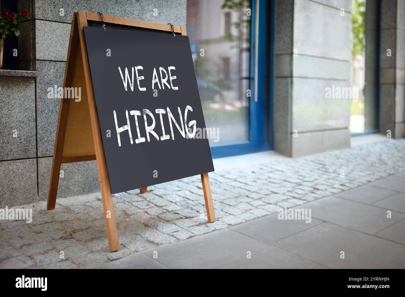 A-board with text We Are Hiring near building. Human resource Stock ...