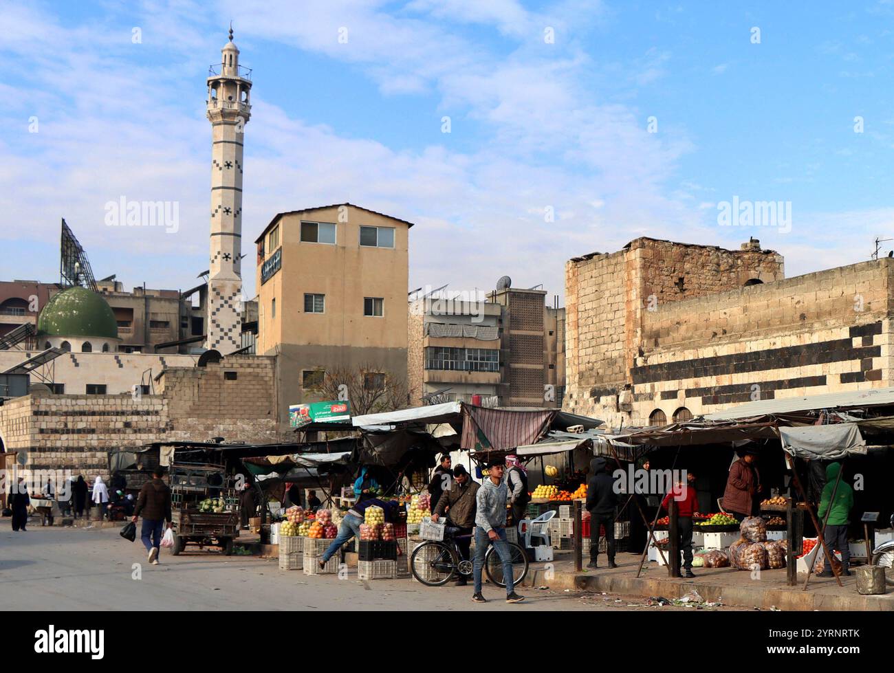 Hama, Syria. 4th Dec, 2024. People shop for fruit and vegetables at a ...