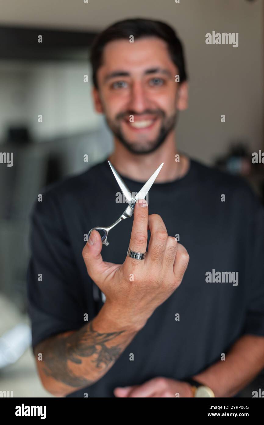 Happy handsome man barbershop master holding scissors in barbershop ...