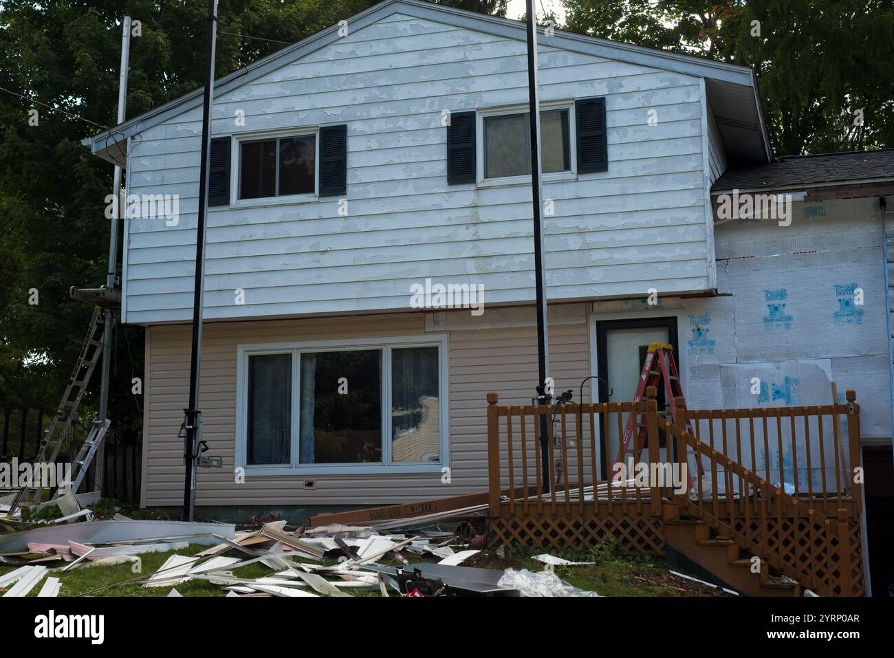 Old aluminum siding with peeling paint on the top portion of a split ...